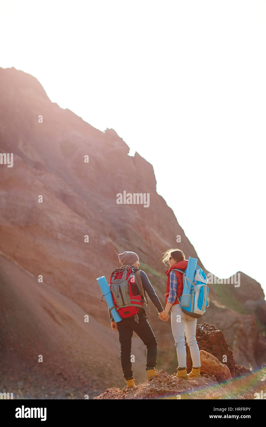 Wide shot sunlit image of two people in hiking gear with tourist ...