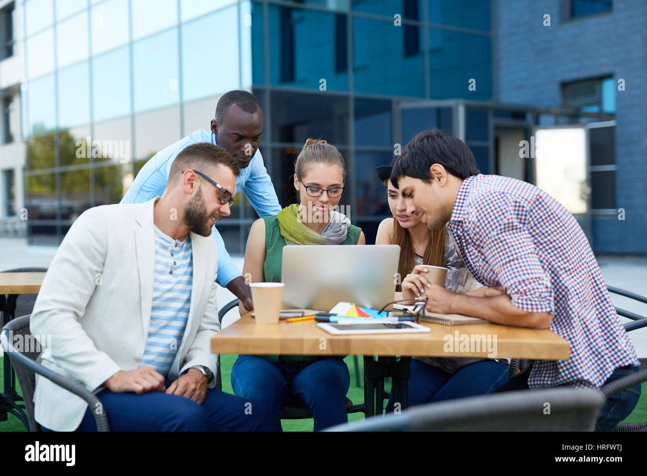 Multi-ethnic group of young creative people working together at outdoor ...