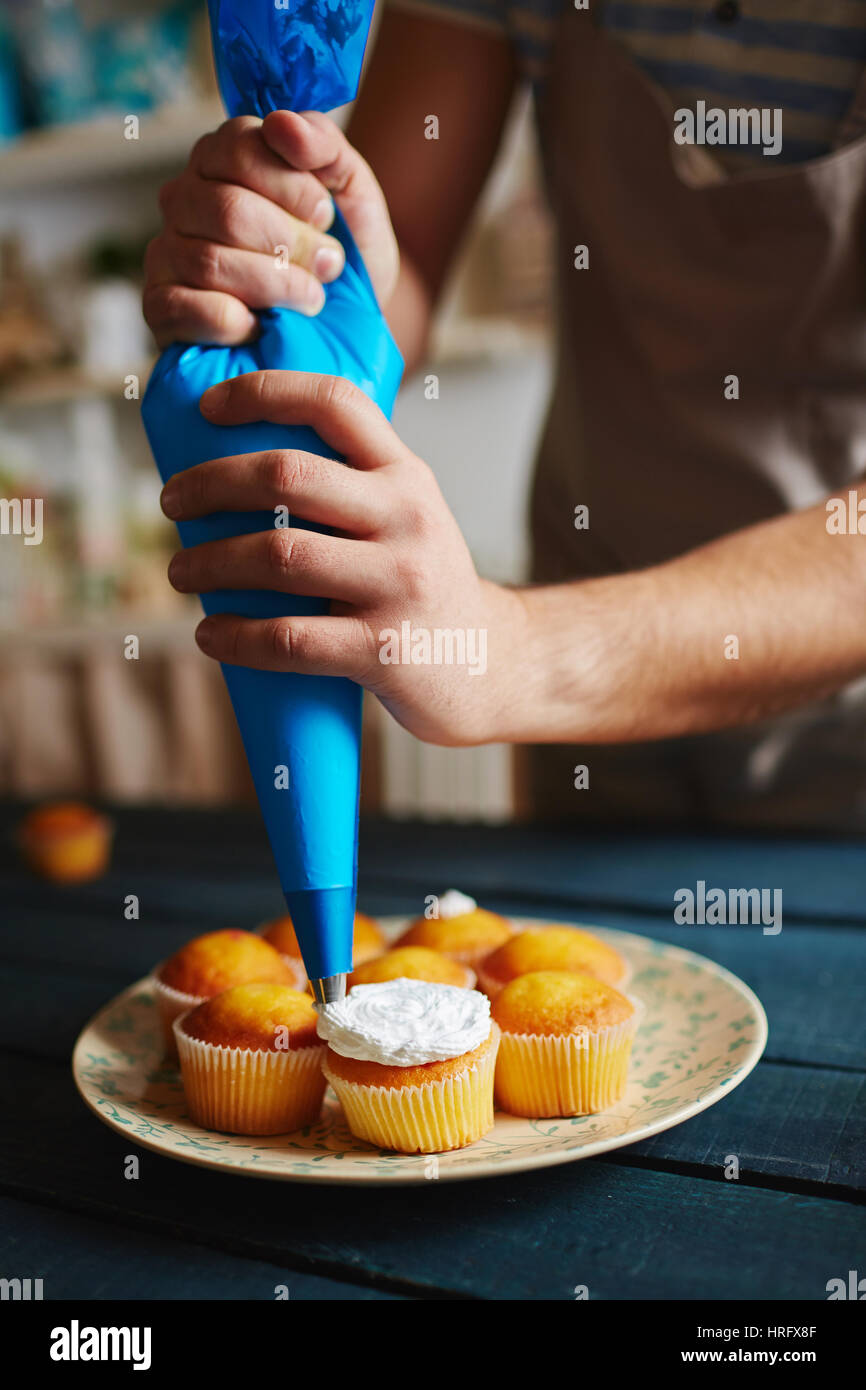 Closeup of unrecognizable man working in rustic kitchen, decorating ...