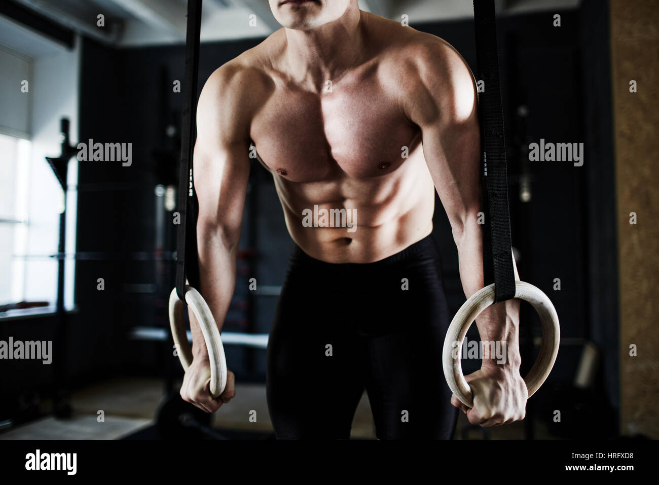 Intense crossfit workout in dark gym: closeup shot of ripped male torso ...