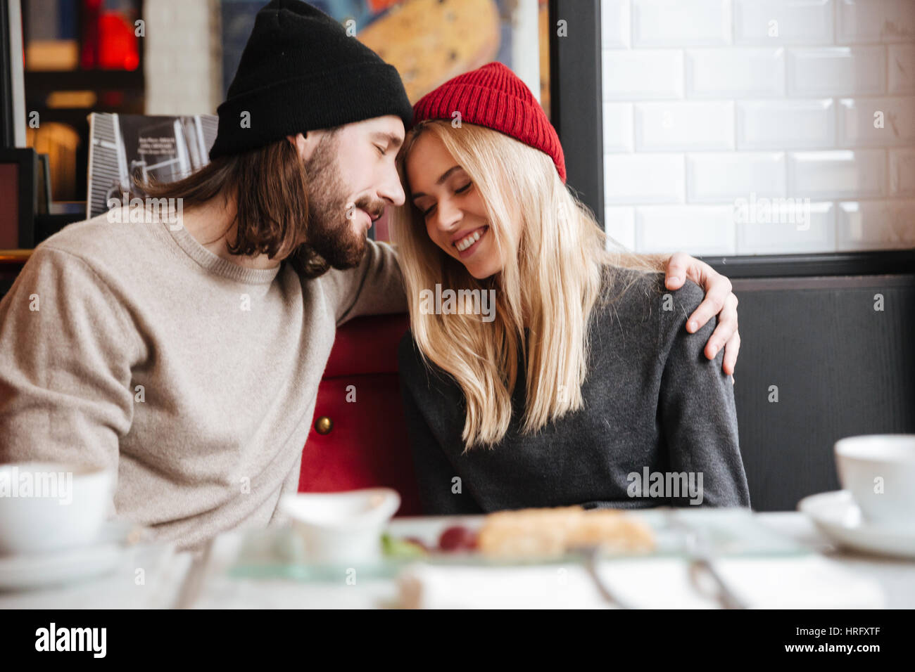Couple sitting together by the table and hugging in cafe Stock Photo ...