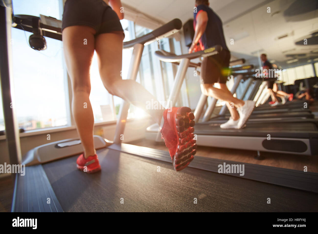 Low-angle view of female legs in shorts and sneakers running on ...