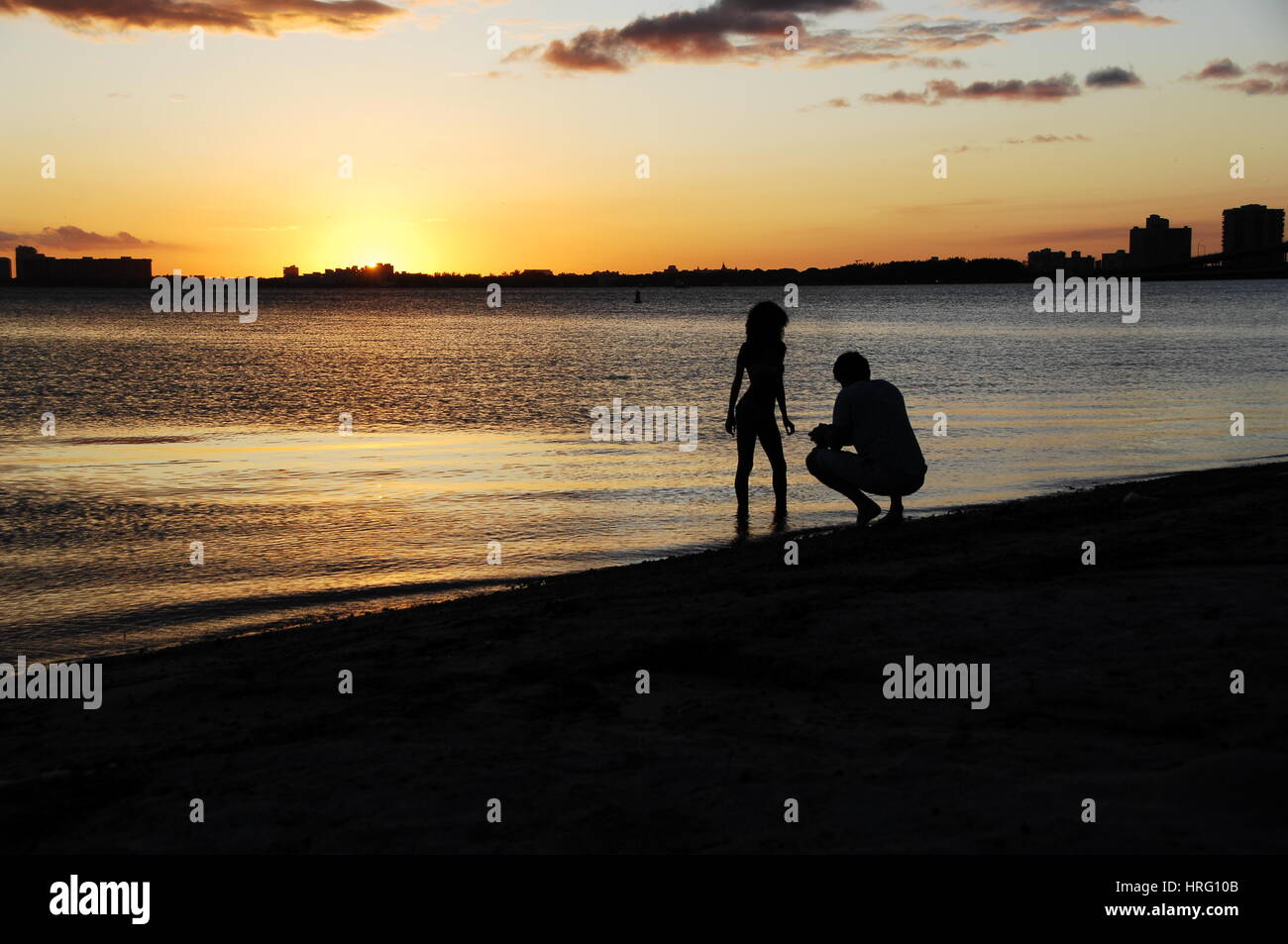 photographer takes pictures of a model at sunset on the sea Miami ...
