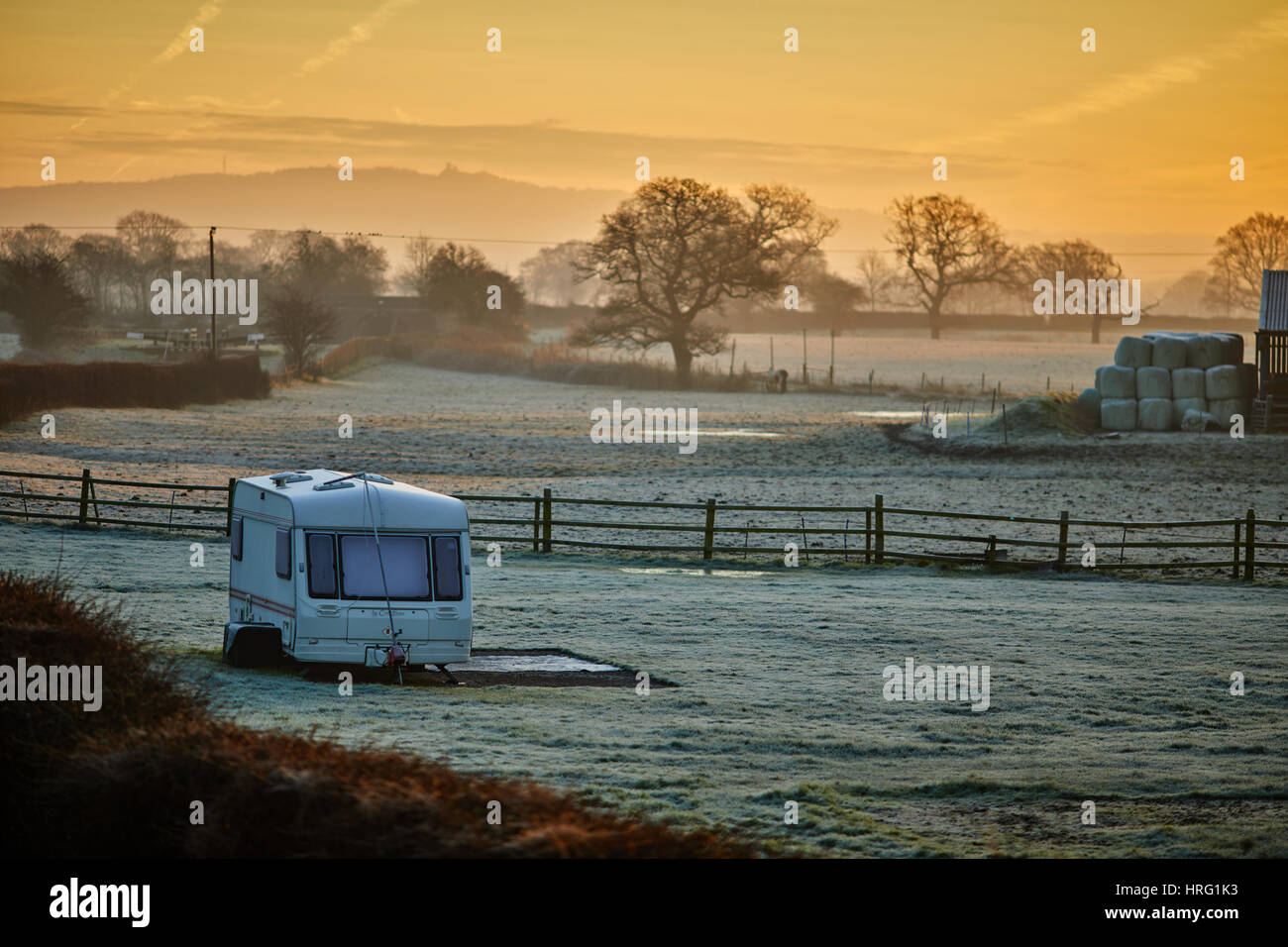 A caravan in a farmers field all alone at sunrise, near Stoke in ...