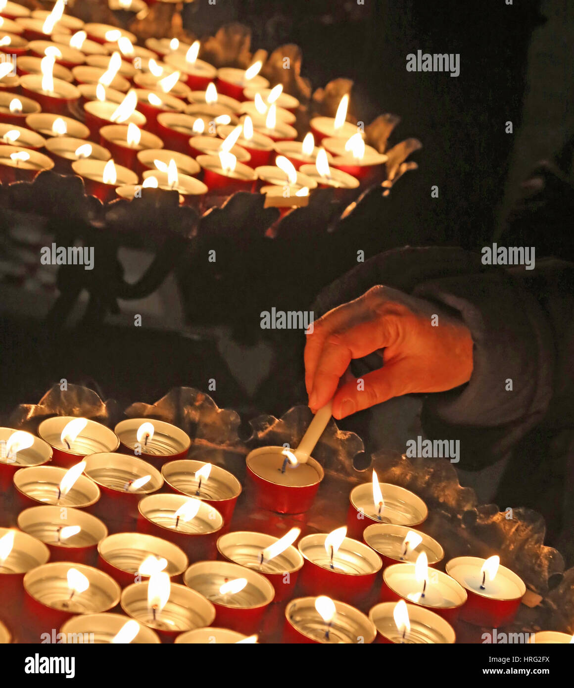 elderly woman hand lighting a candle during the Holy Mass Stock Photo ...
