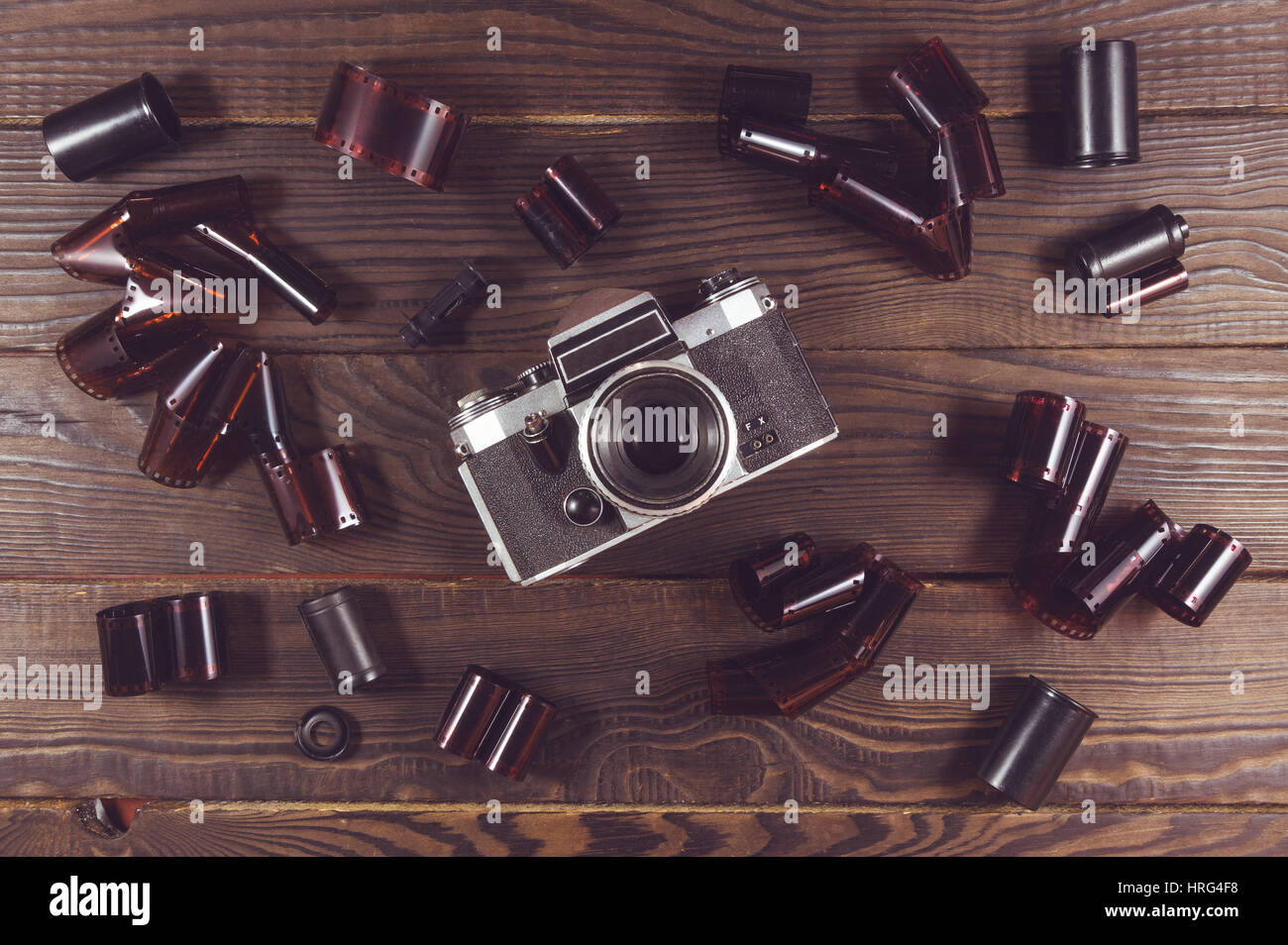 Old camera and films are on the dark wooden surface. Retro. Top view ...