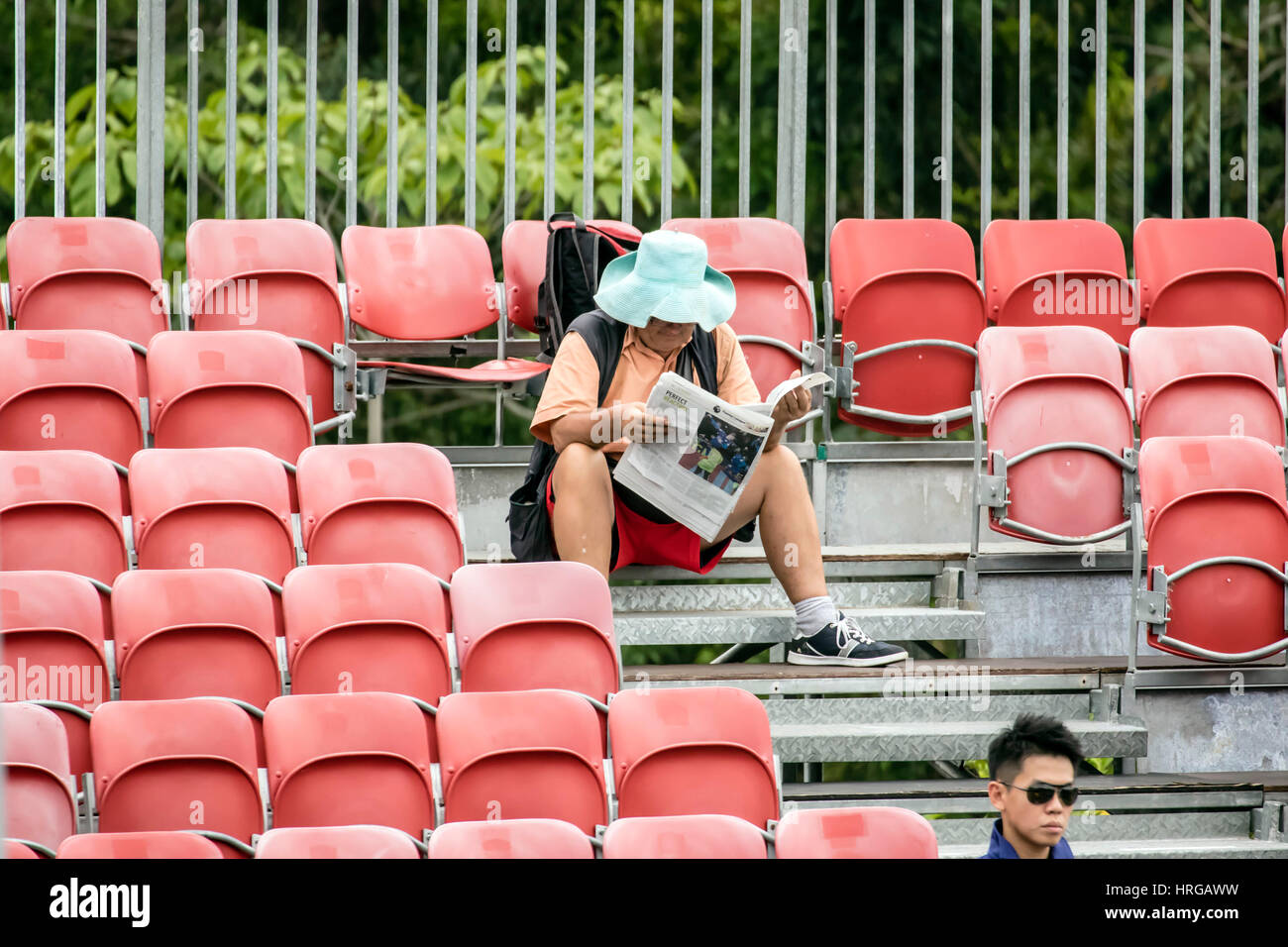 Kuala Lumpur, Malaysia. 1 March, 2017. A tennis spectator reading a ...