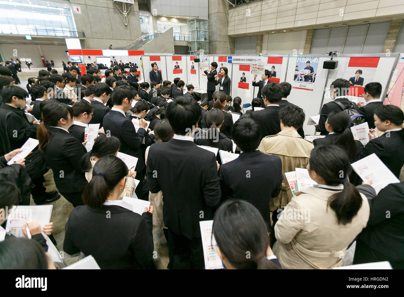 University students listen to a company recruiter at a job fair at ...