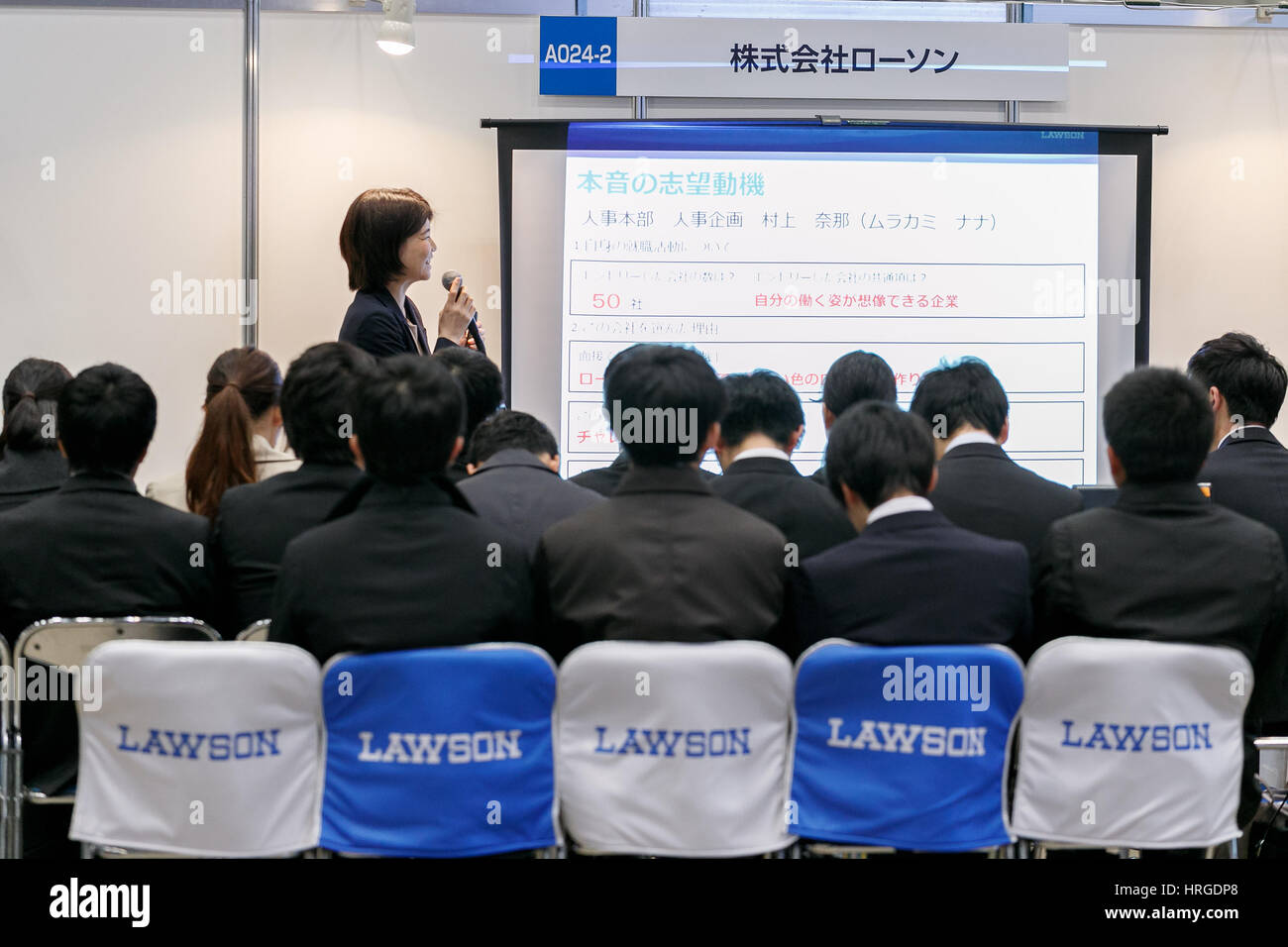 University students listen to a company recruiter at a job fair at ...