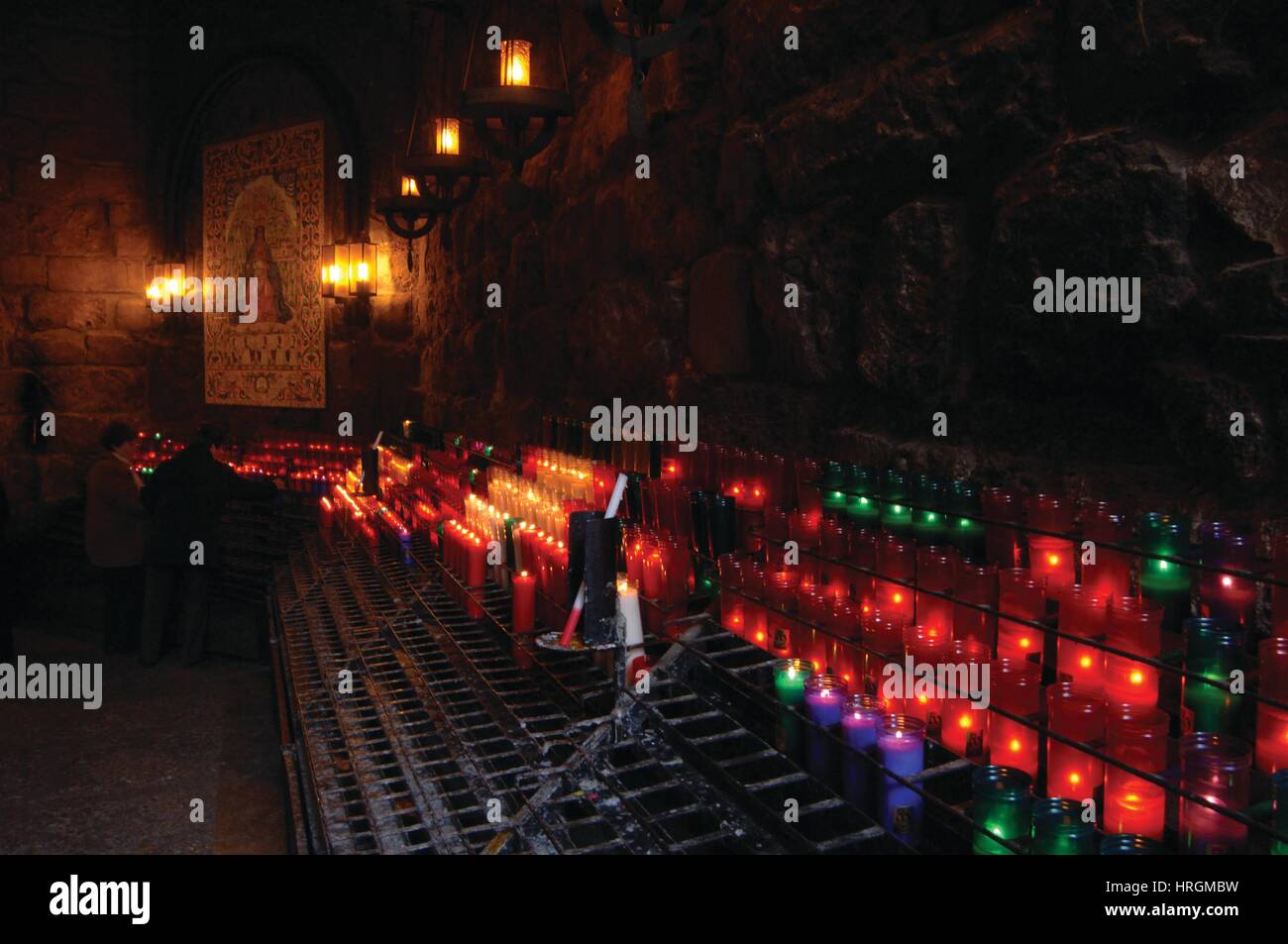 multi-colored lit candles in offering in chapel church at Montserrat ...