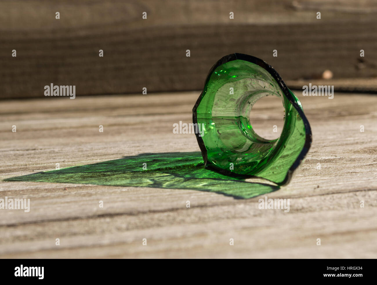 Broken green glass bottle with wood background Stock Photo - Alamy