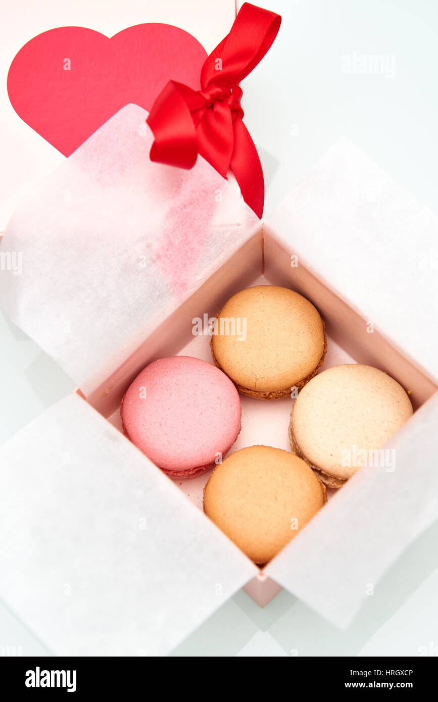 4 colorful macaroons wrapped in the Valentine's Day themed pink box ...