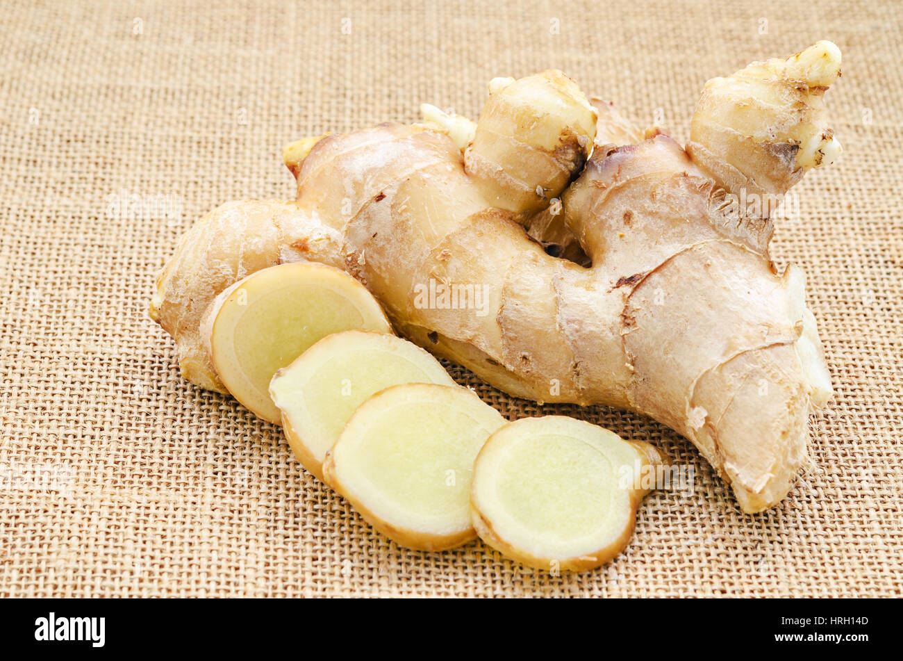Ginger root sliced on sack background Stock Photo - Alamy