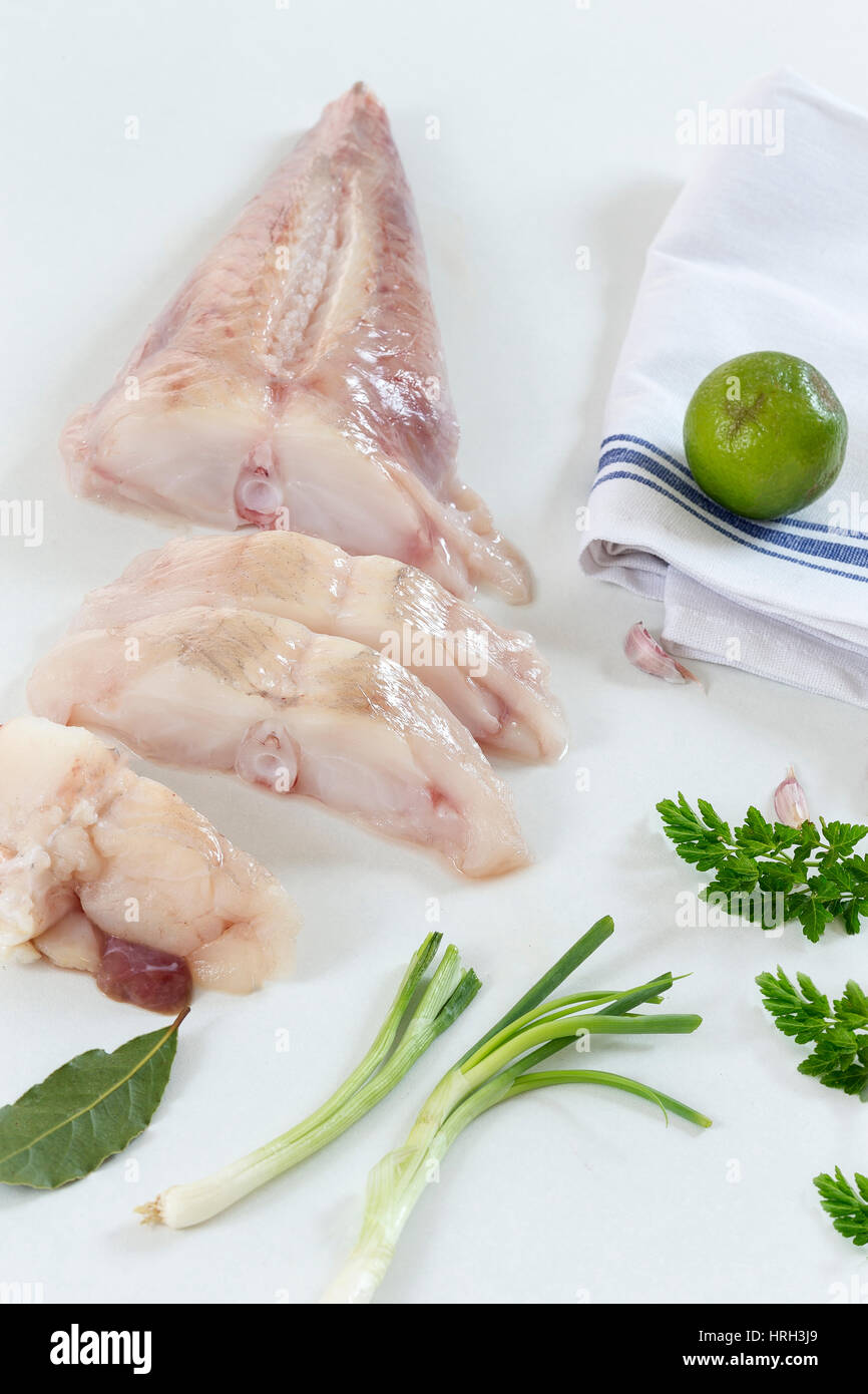 some monkfish slices on a white background Stock Photo - Alamy