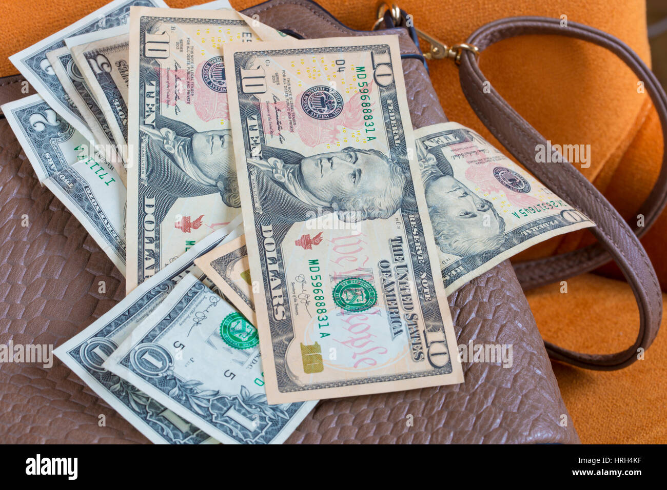 Dollar bills on top of a handbag Stock Photo - Alamy