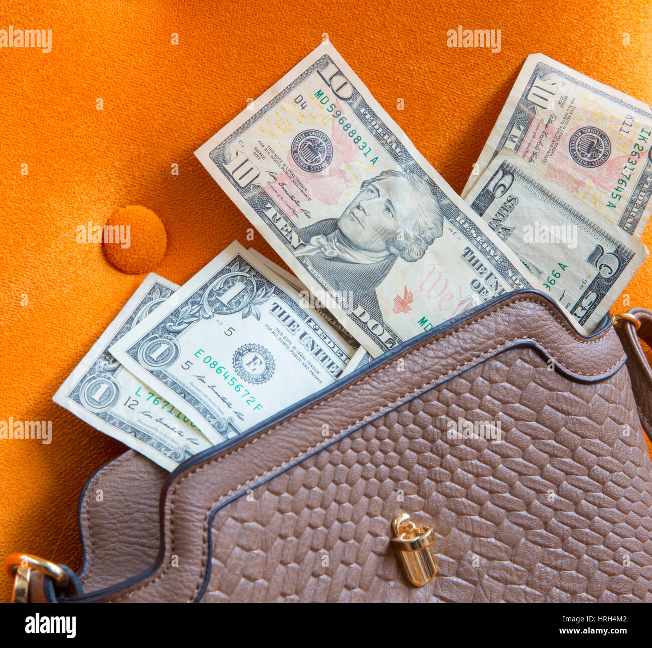 Dollar bills on top of a handbag Stock Photo - Alamy