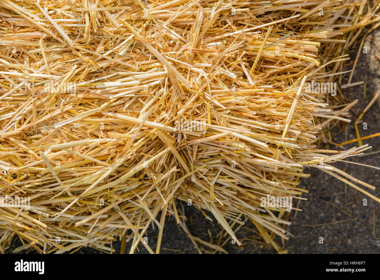 A bunch of yellow straw on the black background of an empty slab of ...