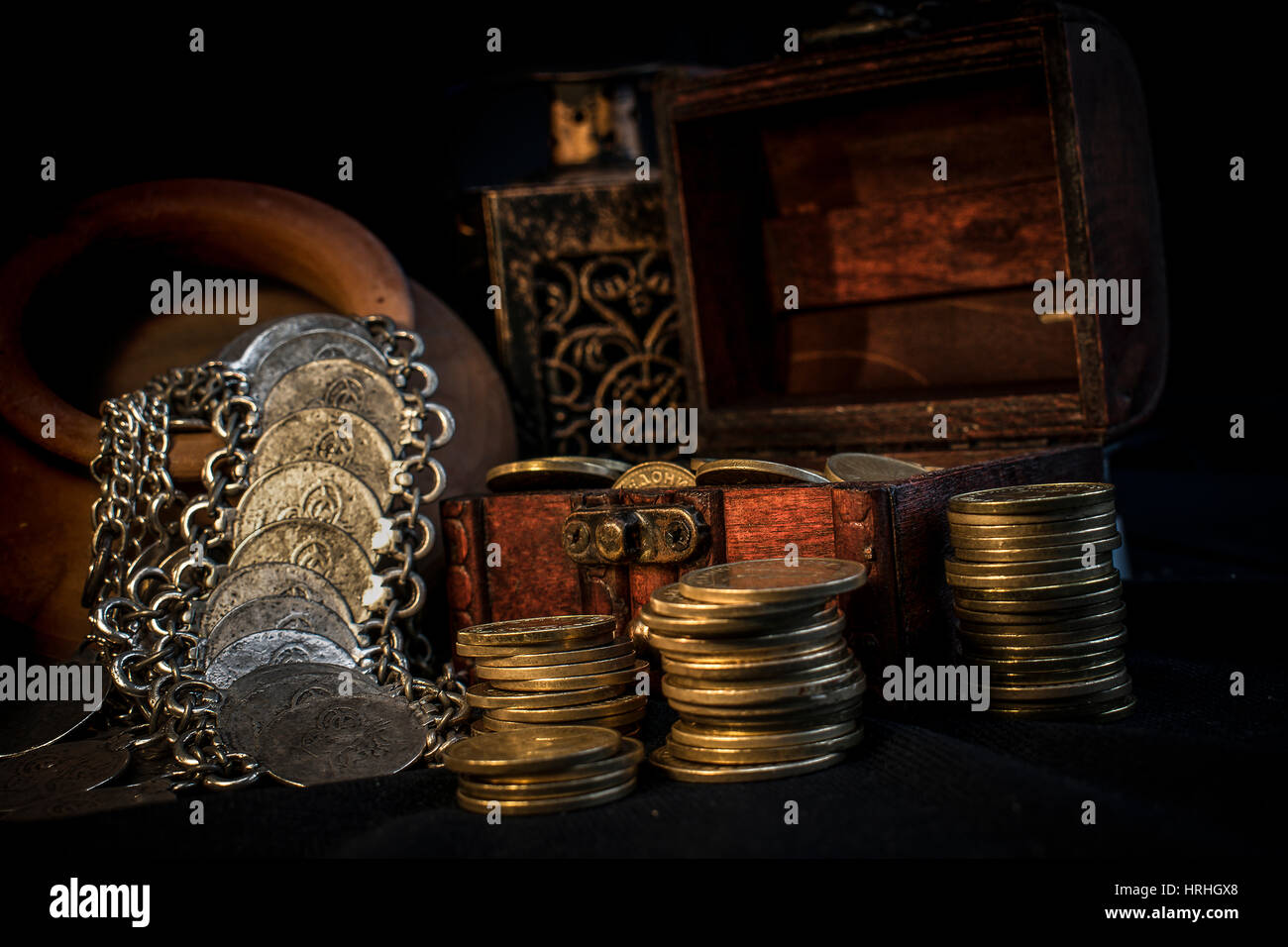 Treasure chest, pile and pillar of coins, a ceramic bowl filled with ...