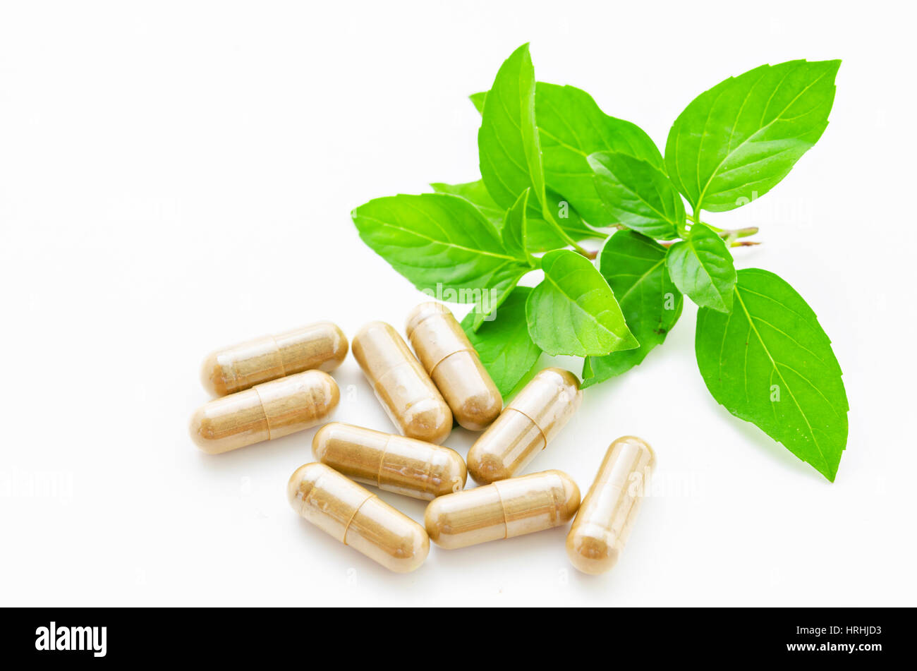 herbal drug capsule and green leaf on white background Stock Photo - Alamy