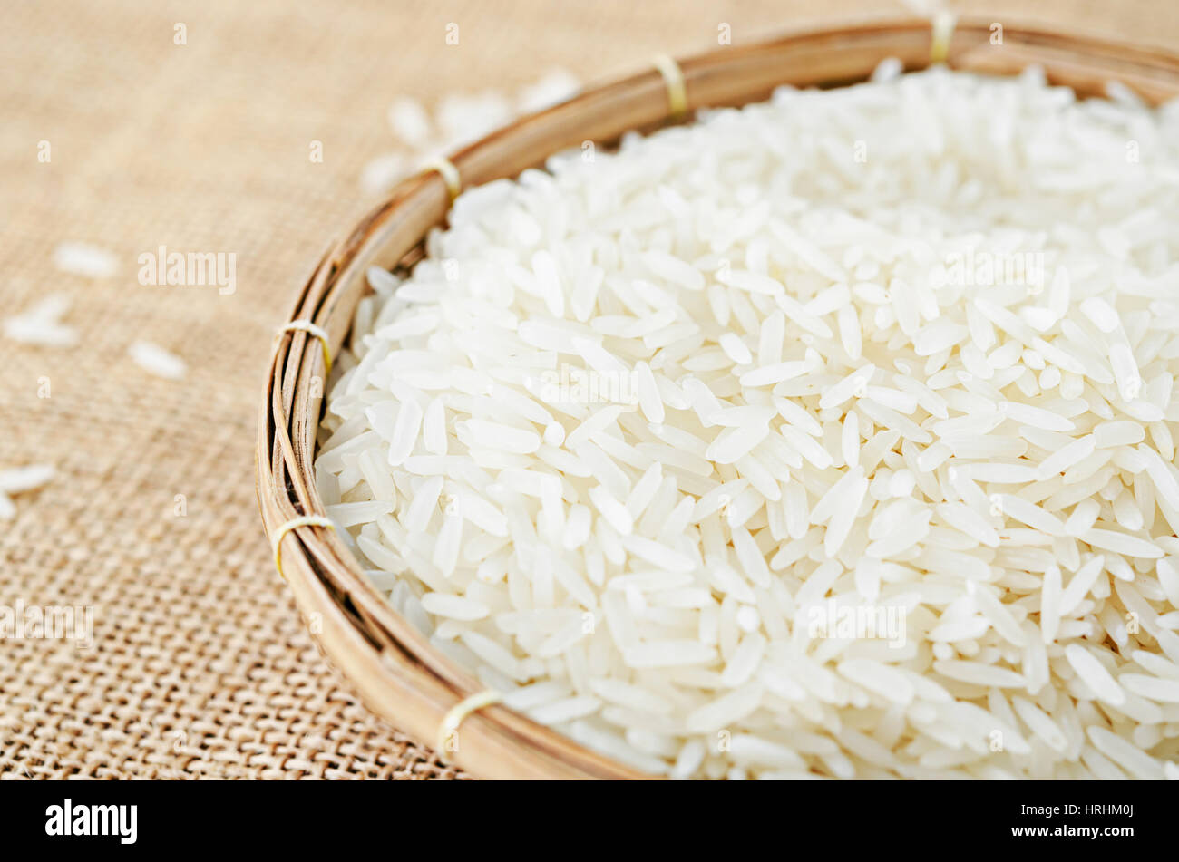 Raw white rice in wood weave basket on sack background Stock Photo - Alamy