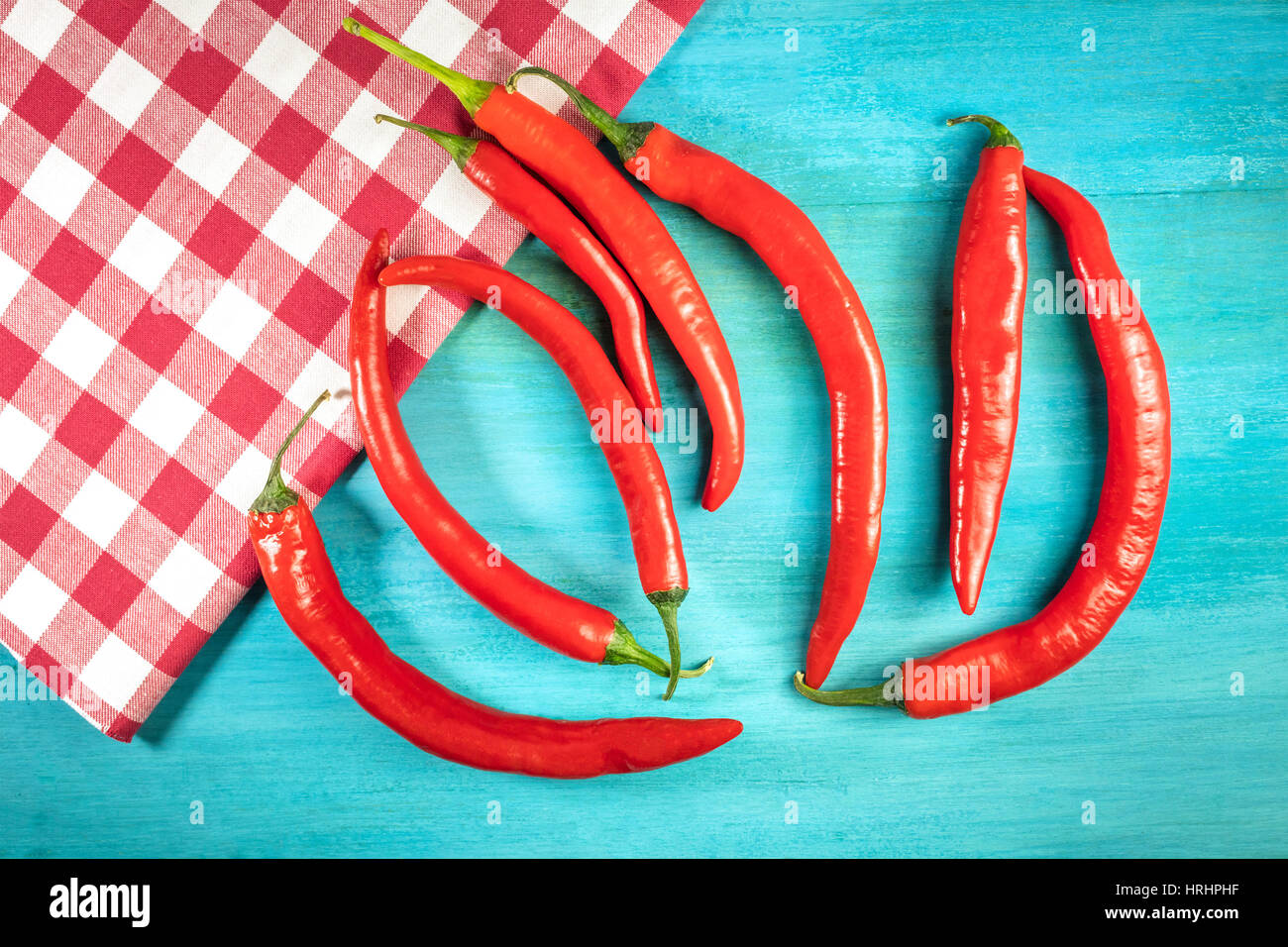 Red hot chili peppers on a vibrant turquoise texture Stock Photo - Alamy