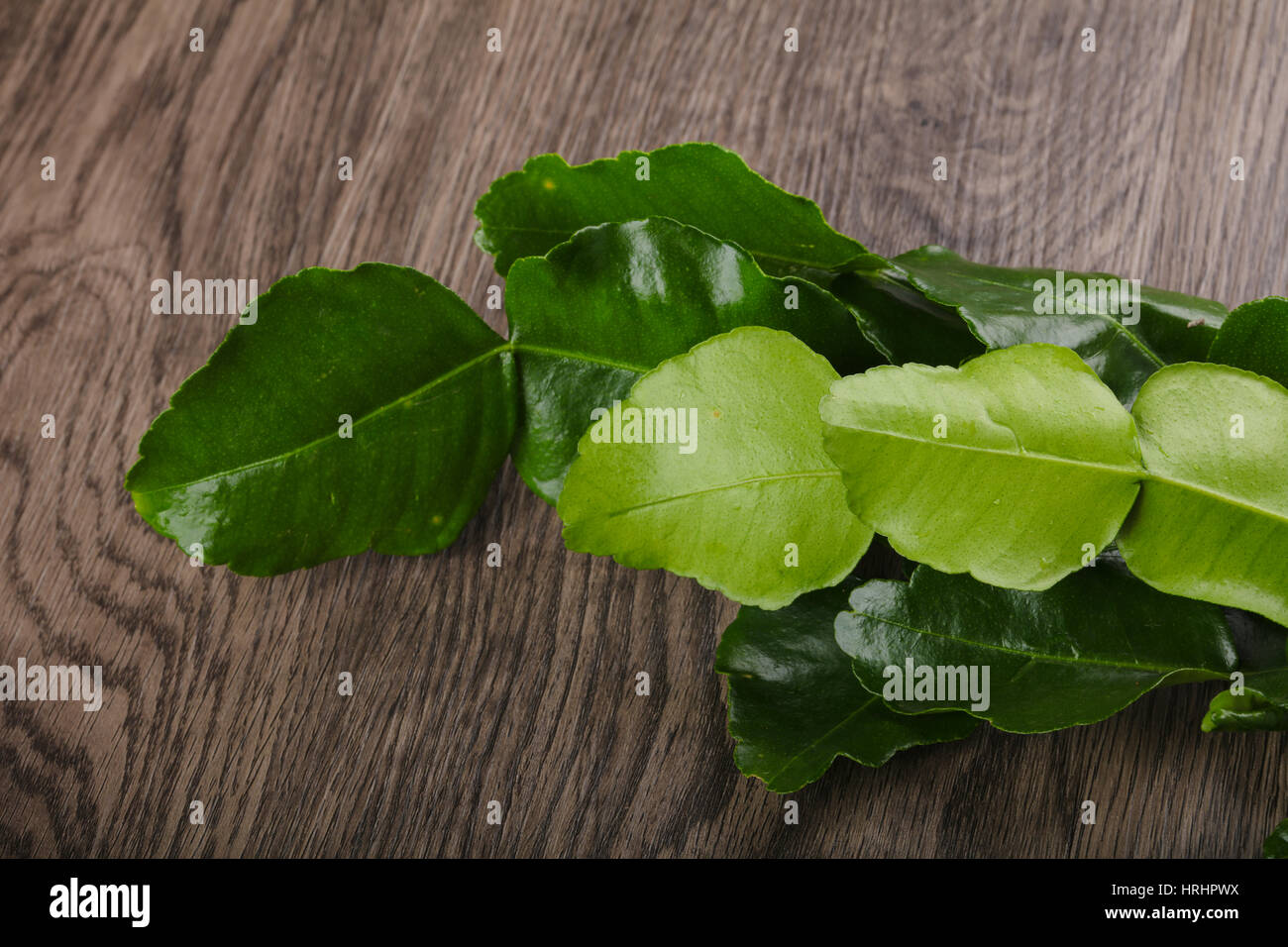 Kafir lime leaves on the wood background Stock Photo - Alamy