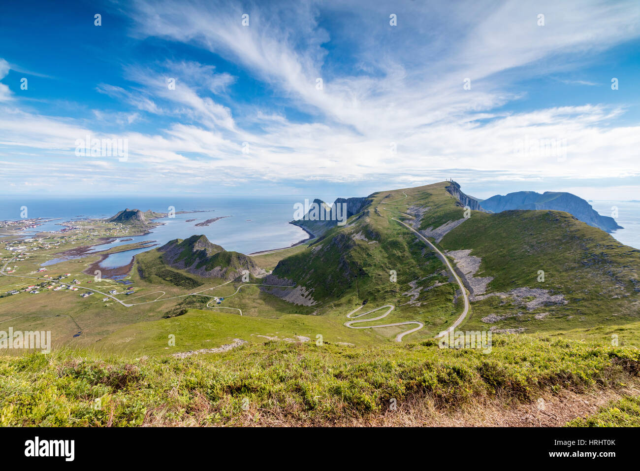Steep road of curves in between green meadows and sea, Sorland, Vaeroy ...