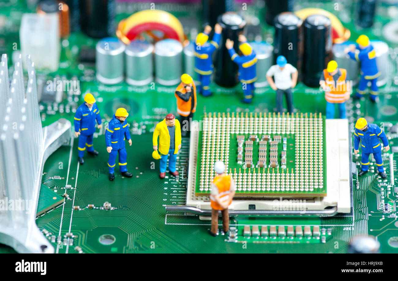 Group of miniature engineers inspecting computer processor Stock Photo ...