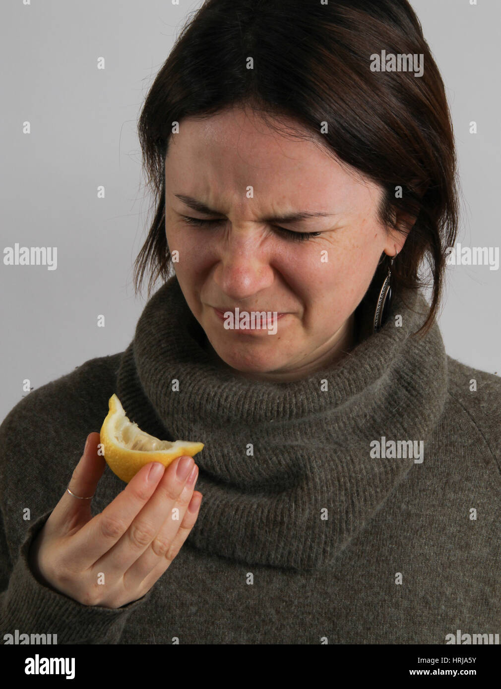 Woman Biting into a Lemon Stock Photo - Alamy