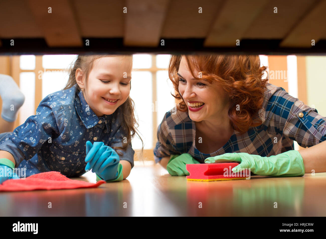 Happy family mother and kid daughter clean room at home. Middle-aged ...