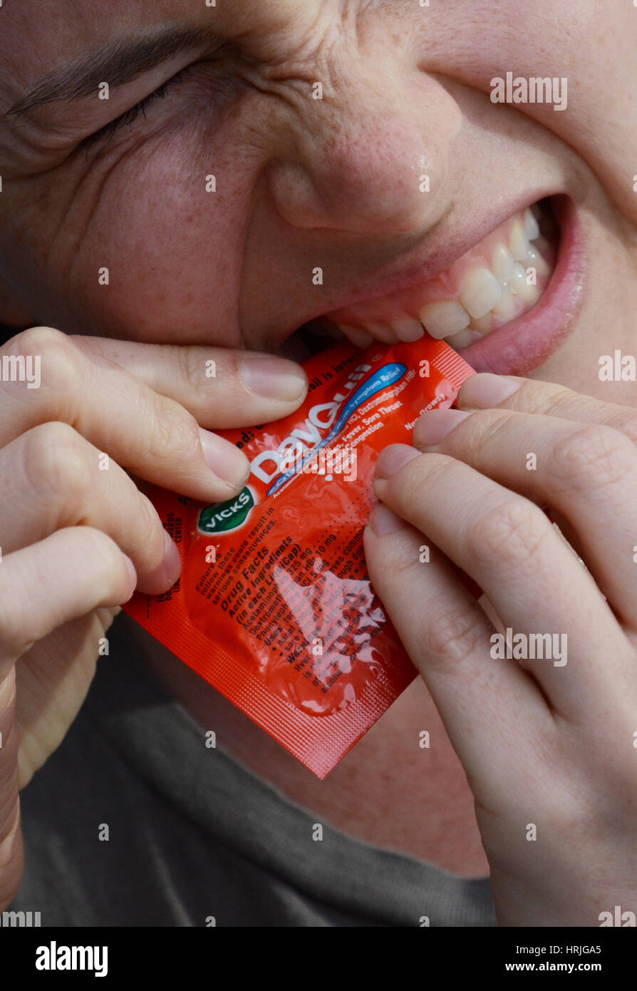 Using Teeth to Open a Packet Stock Photo - Alamy