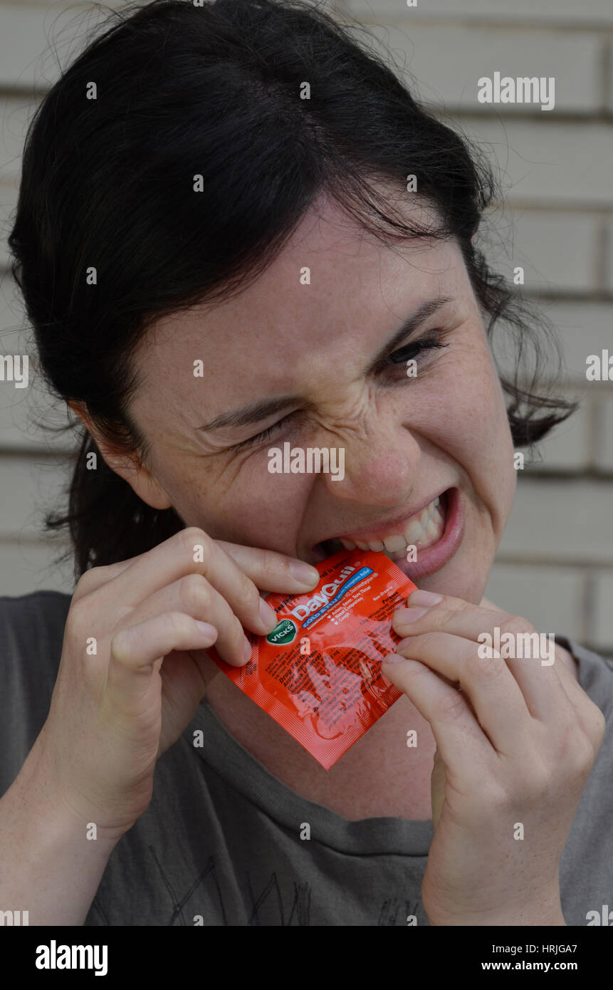 Using Teeth to Open a Packet Stock Photo - Alamy