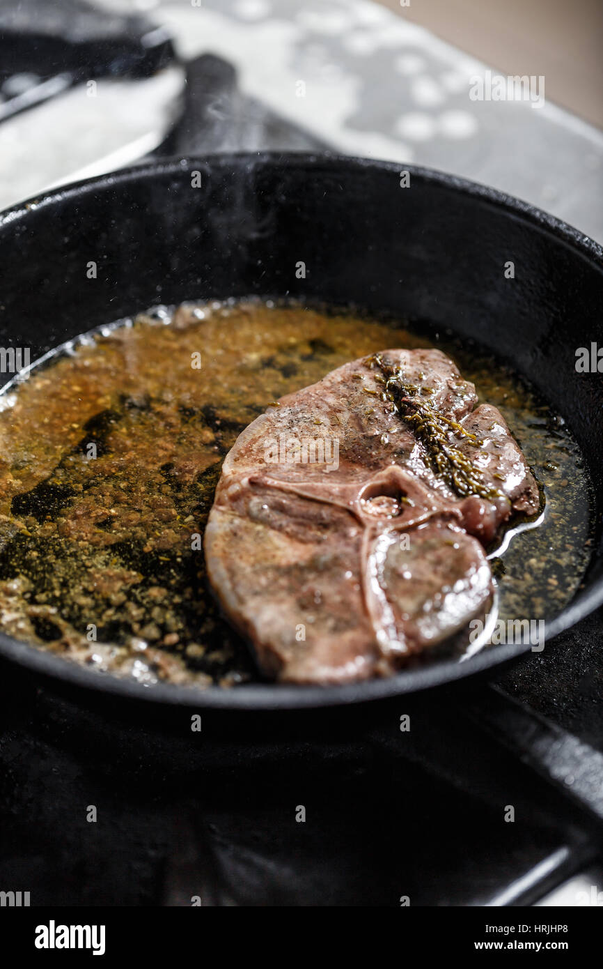 Wild boar steak fried in pan in restaurant kitchen Stock Photo - Alamy