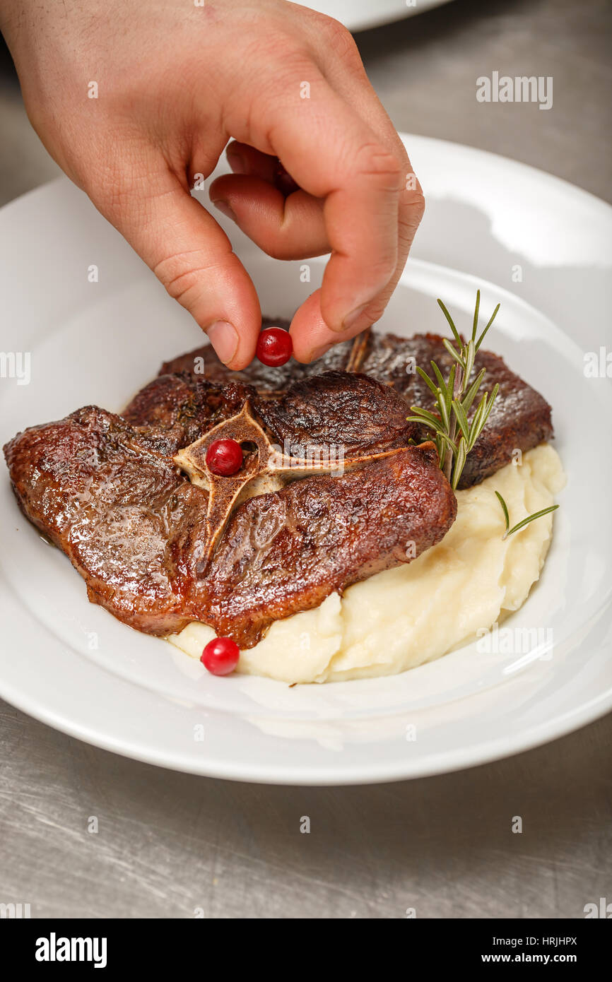 Chef finishing her plate and almost ready to serve Stock Photo - Alamy