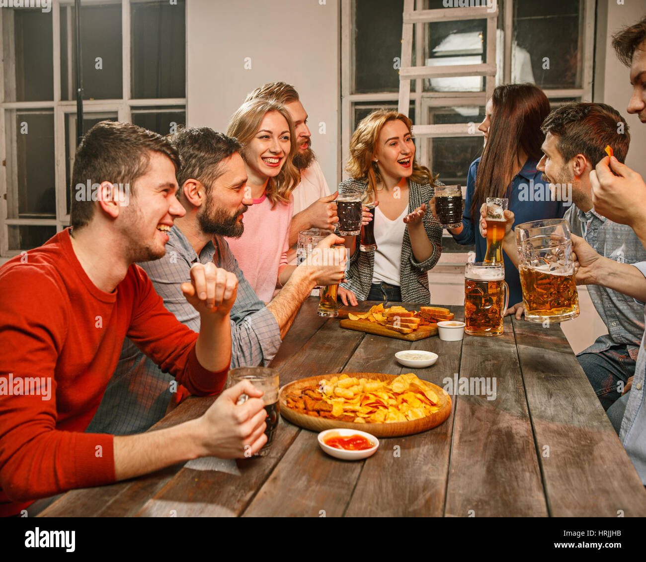 Happy friends clinking drinks bar hi-res stock photography and images ...