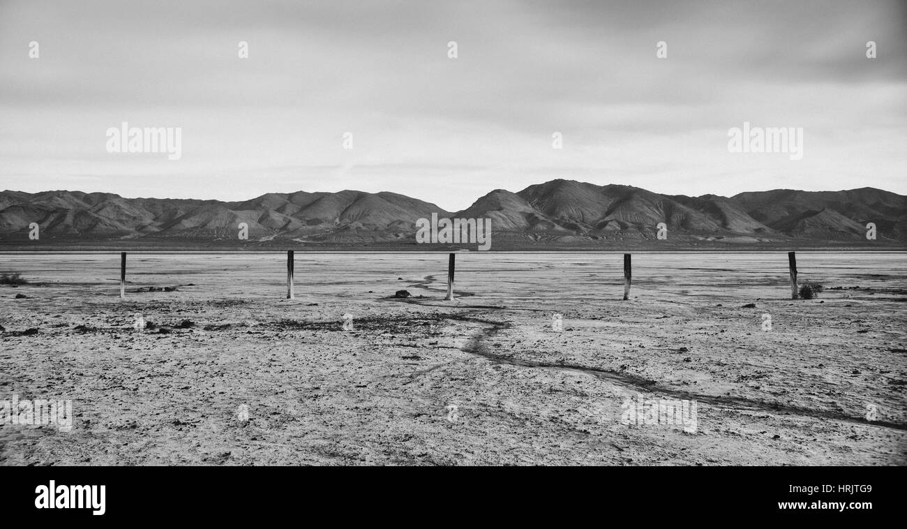 Posts in a desert landscape, with mountains behind Stock Photo - Alamy