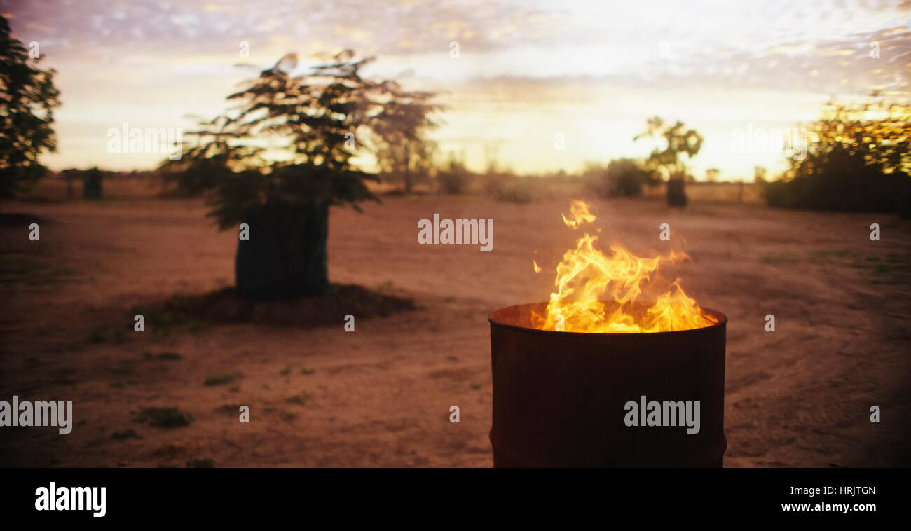 A fire burning in a barrel in an outback landscape Stock Photo - Alamy