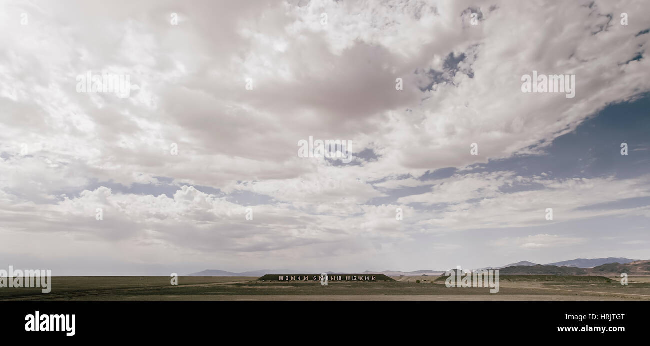 Numbers on a wall in a desert landscape with mountains in the distance ...