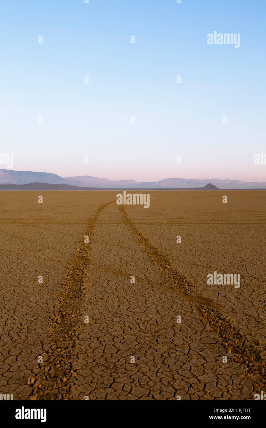 Tyre tracks in a desert landscape with mountains in the distance Stock ...