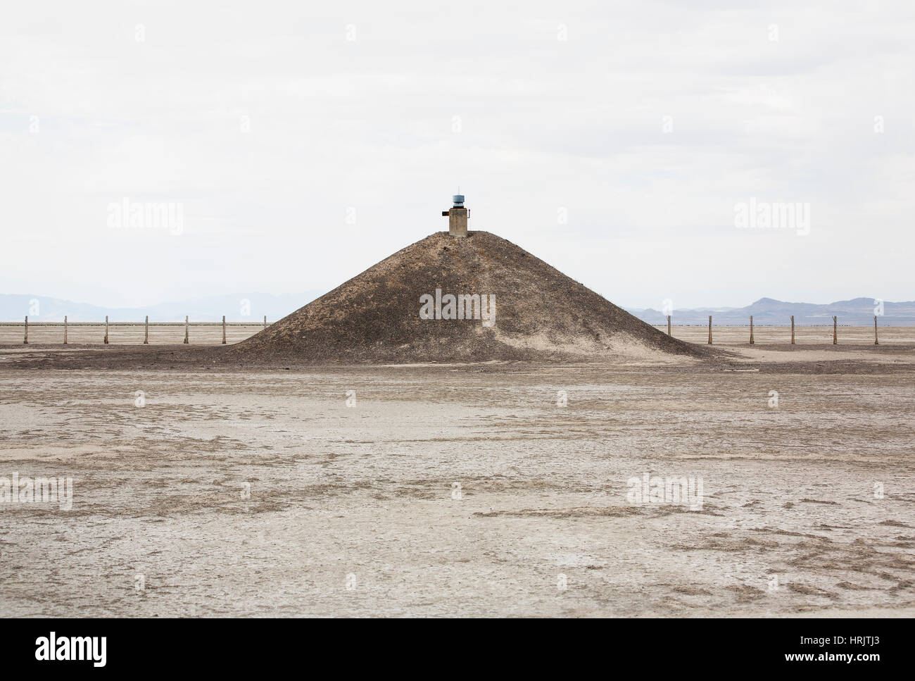 A mound in a flat landscape with a mountain range in the distance Stock ...