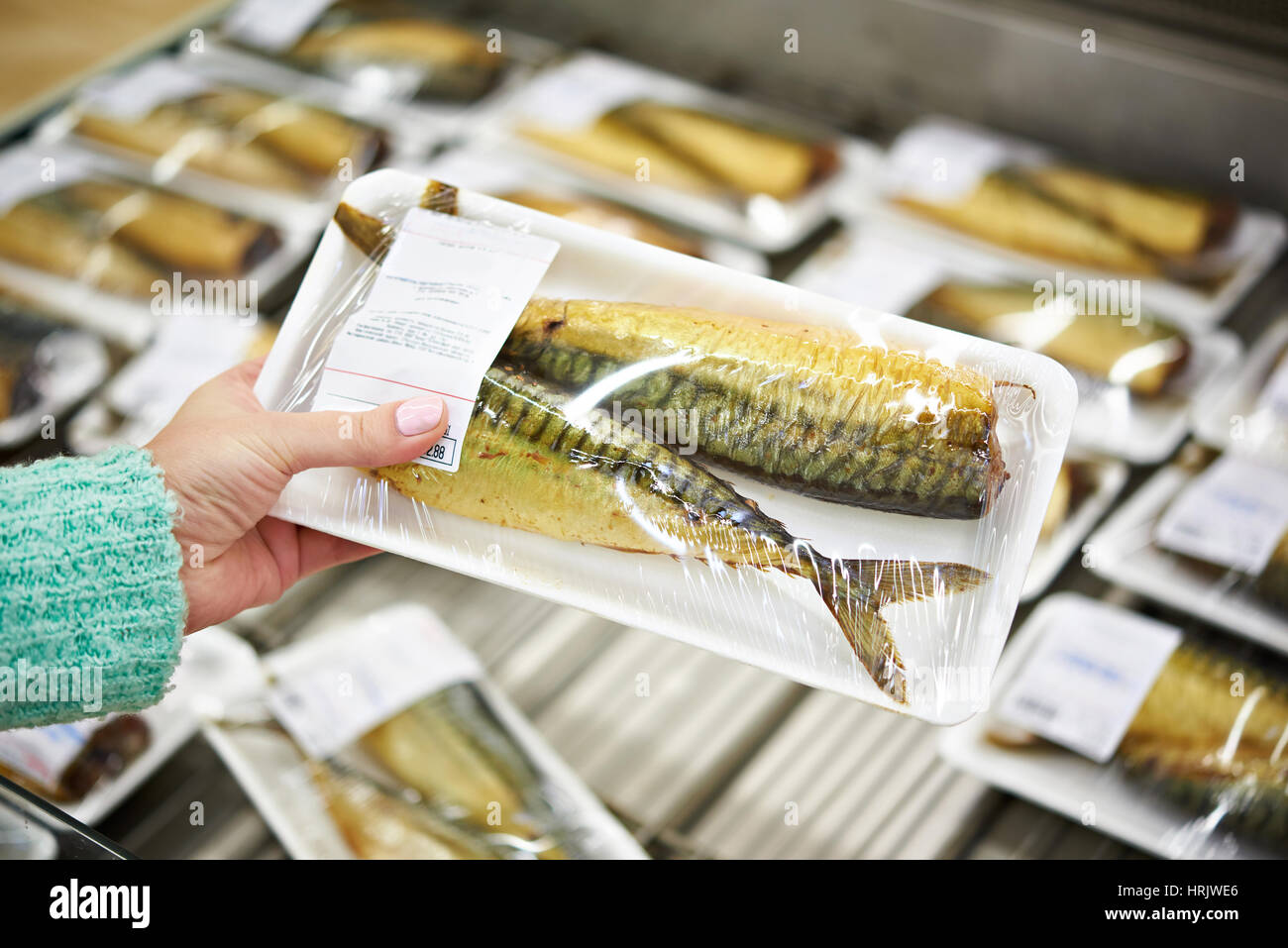 Buyer chooses smoked fish mackerel in supermarket Stock Photo - Alamy