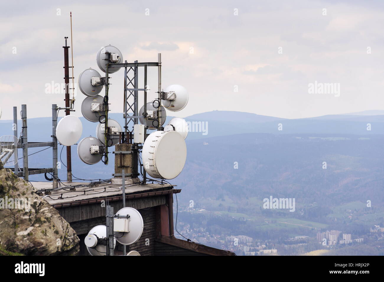 Telecommunication transmitters and aerials with city in background ...