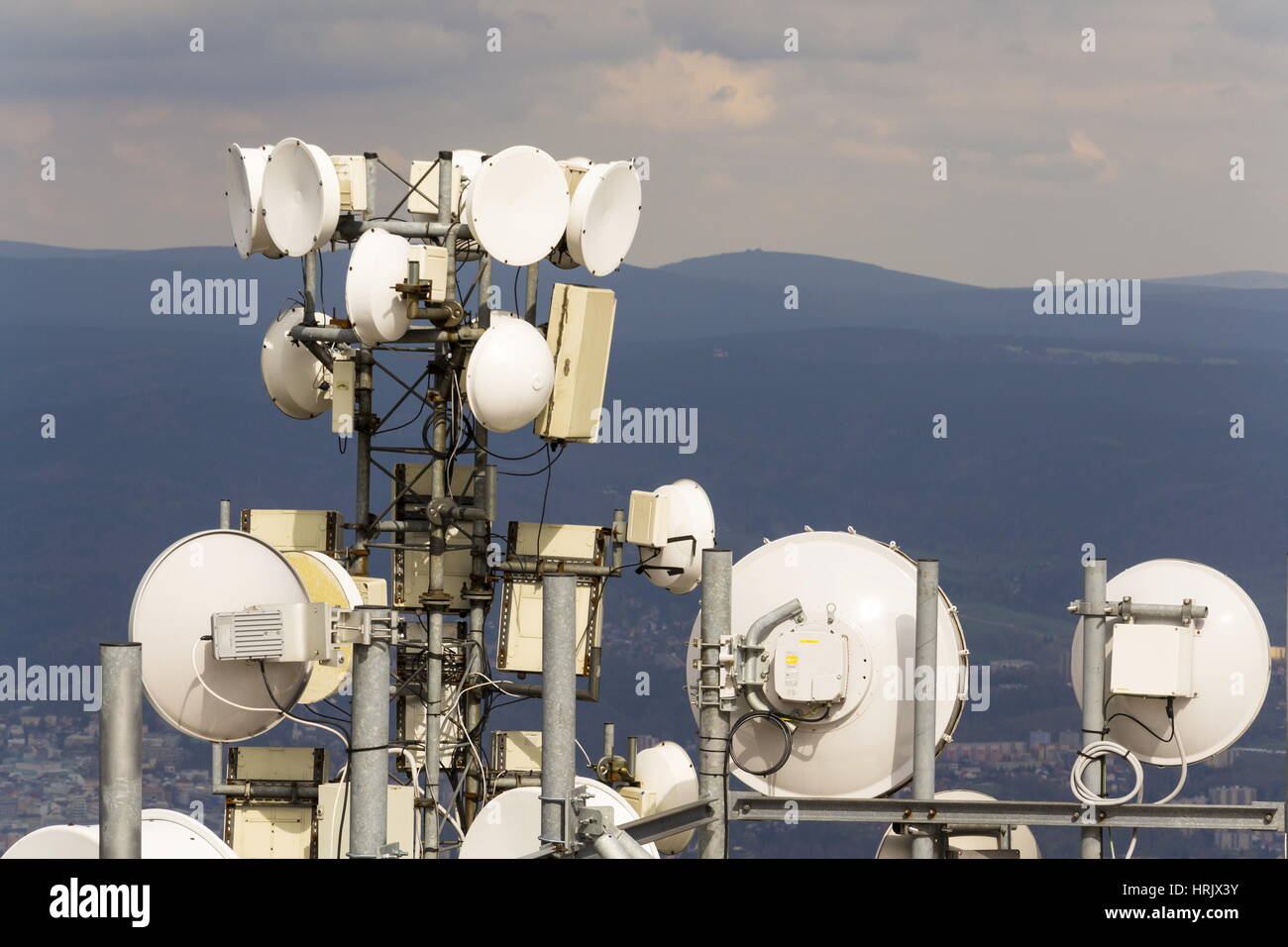 Telecommunication transmitters and aerials with city in background ...