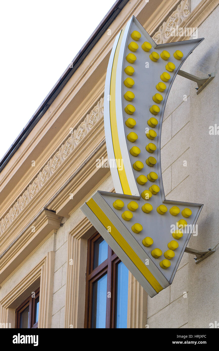 vertical front view of arrow vintage light bulb sign pointing down on a ...