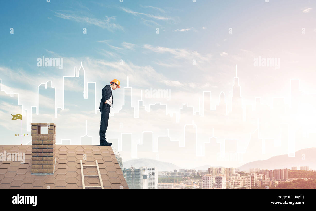 Engineer man standing on roof and looking down. Mixed media Stock Photo ...