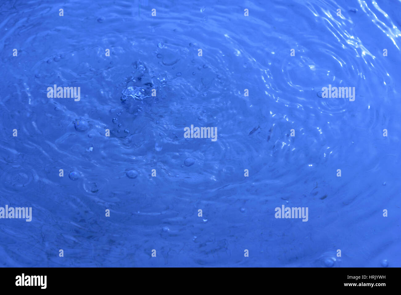 blue water dripping - splash droplets with small waves Stock Photo - Alamy