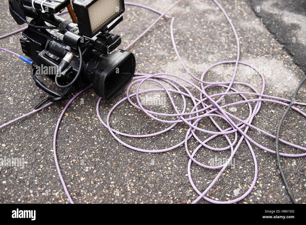 Detail with a video camera with cable laying on asphalt Stock Photo - Alamy