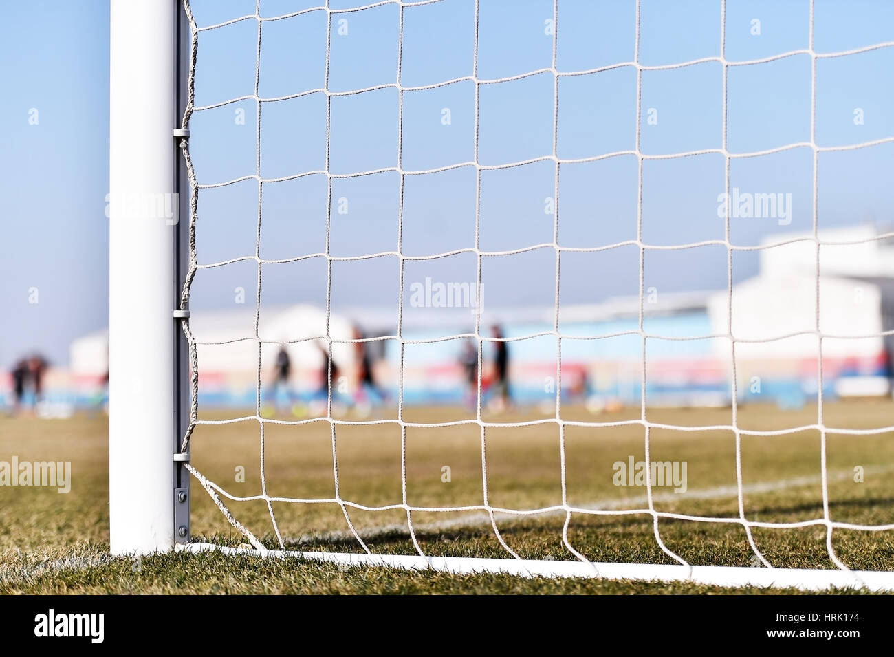 Soccer goalpost and players training in the background Stock Photo - Alamy
