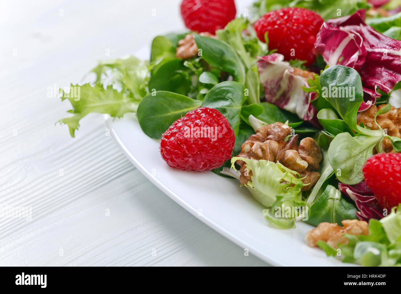 Vegan spring salad with raspberries and nuts on white plate Stock Photo ...
