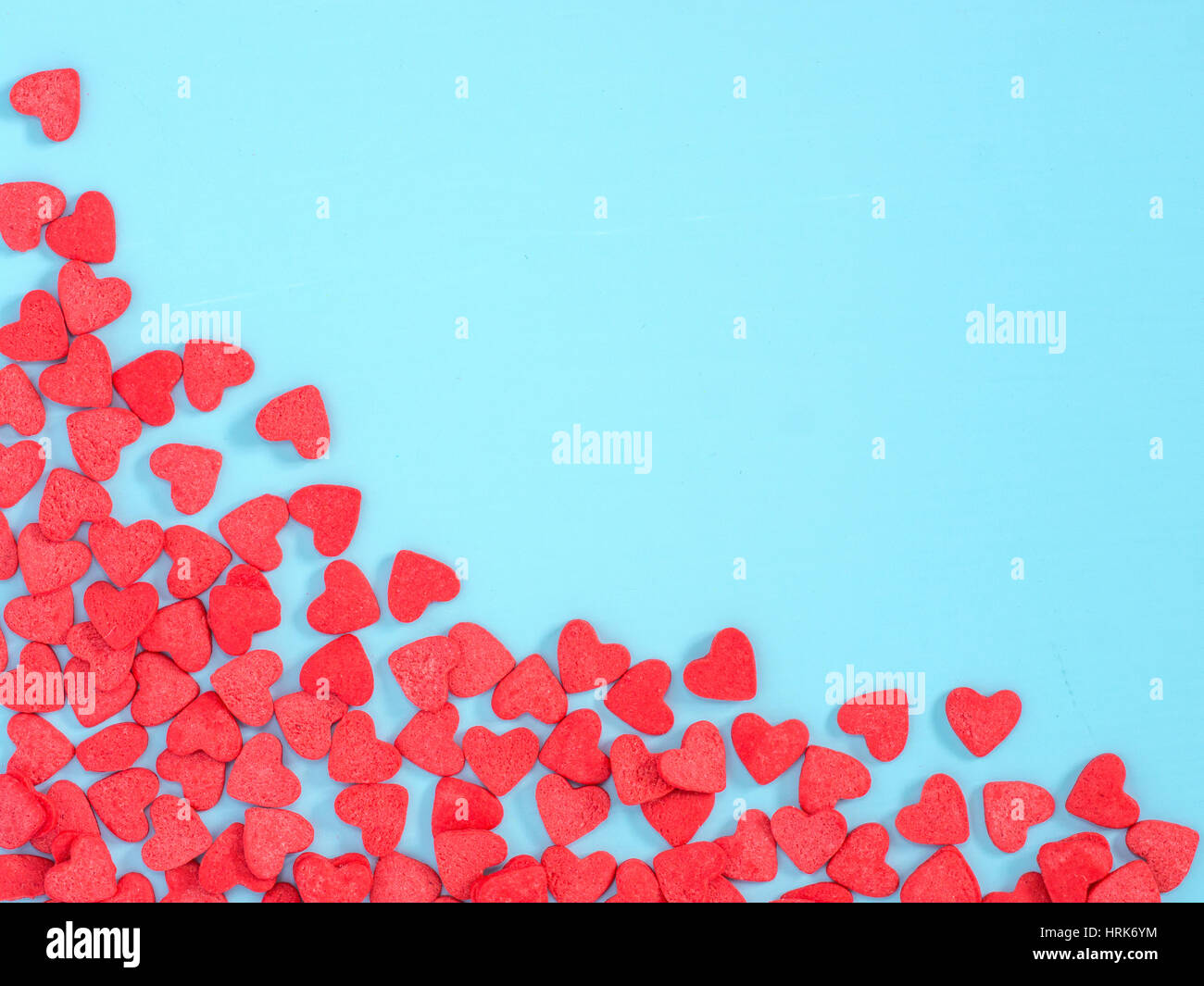 Border frame of red hearth-shape sprinkles on blue background with ...